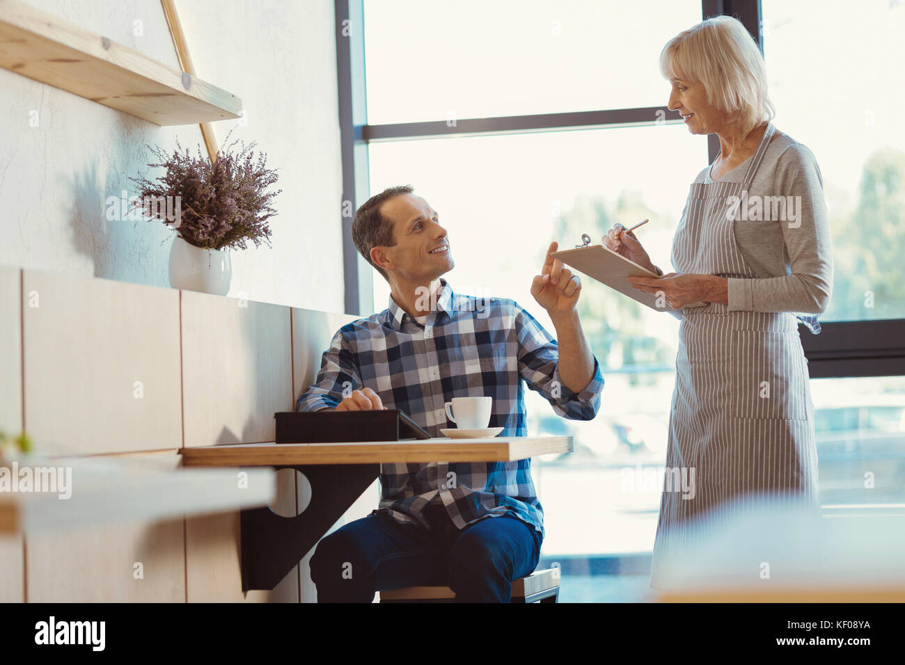 Positive joyful man talking to a waitress Stock Photo - Alamy