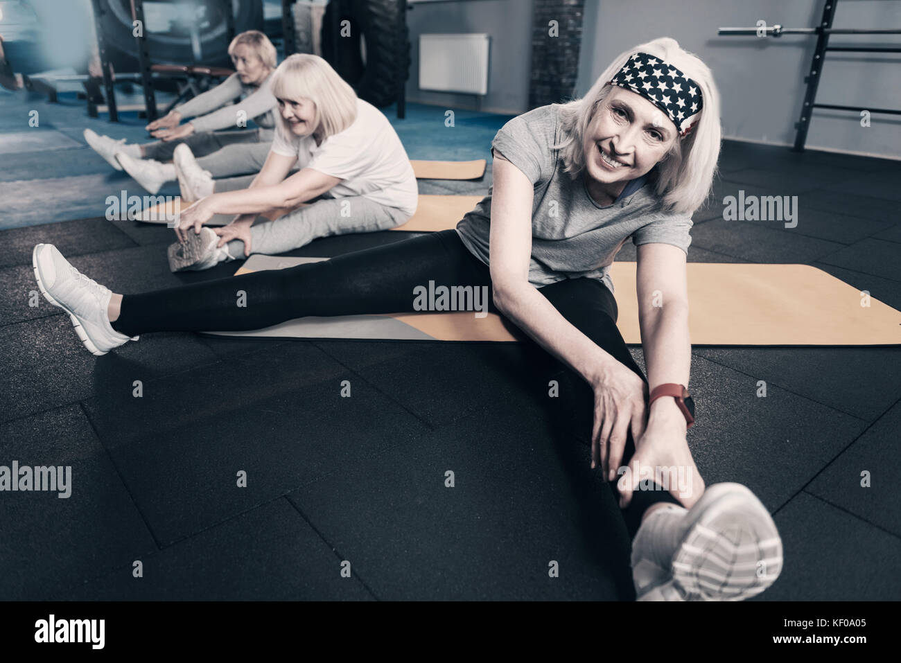 Three senior women performing leg stretches Stock Photo - Alamy