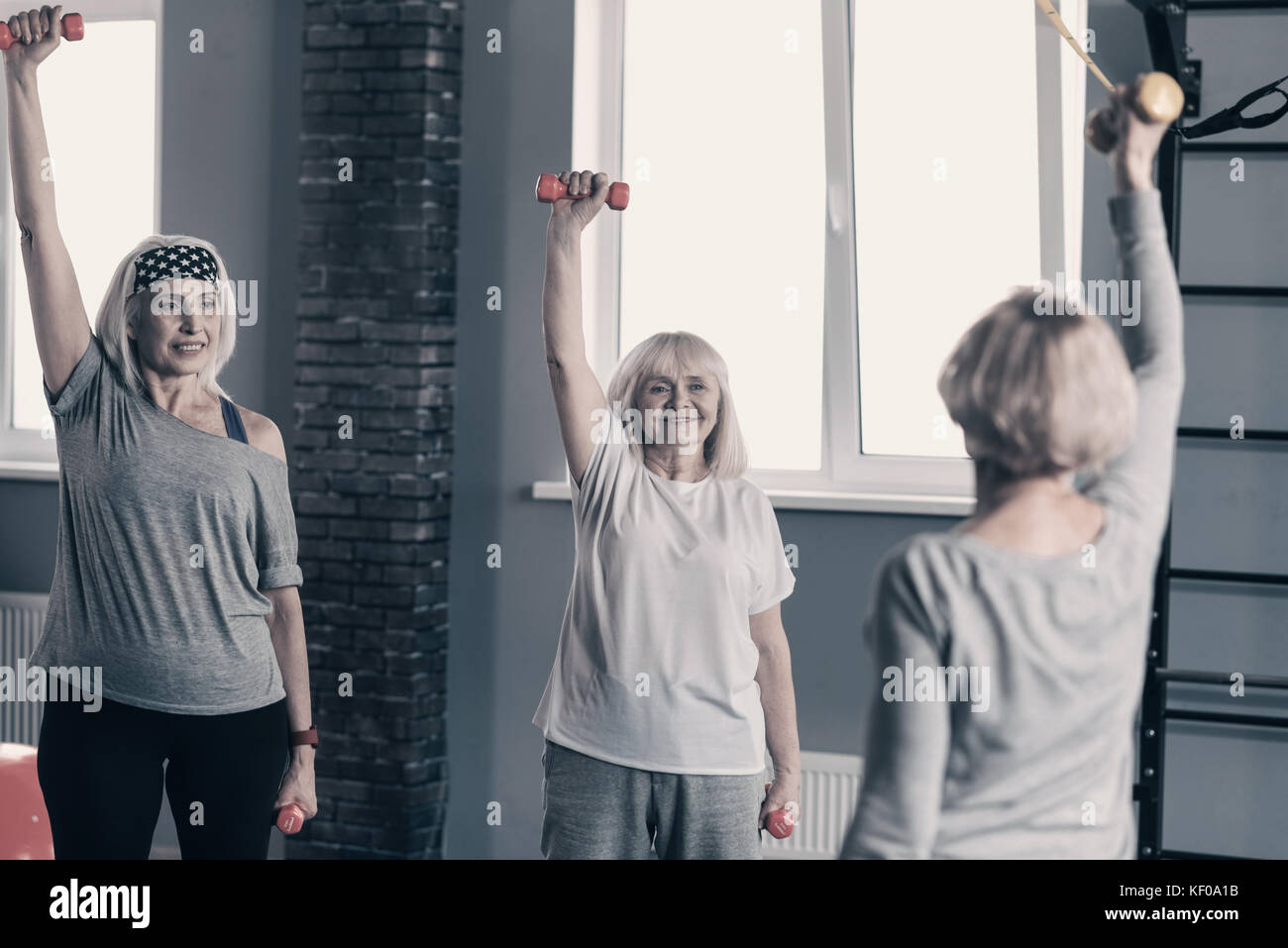 Energetic women repeating dumbbells workout after their trainer Stock ...