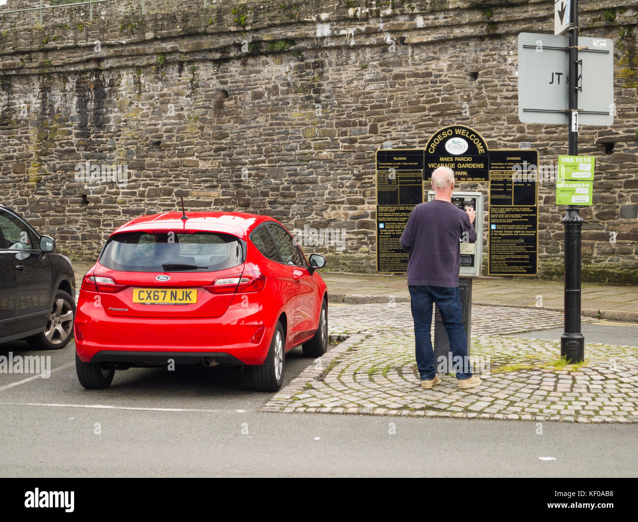 man feeding parking meter Stock Photo - Alamy