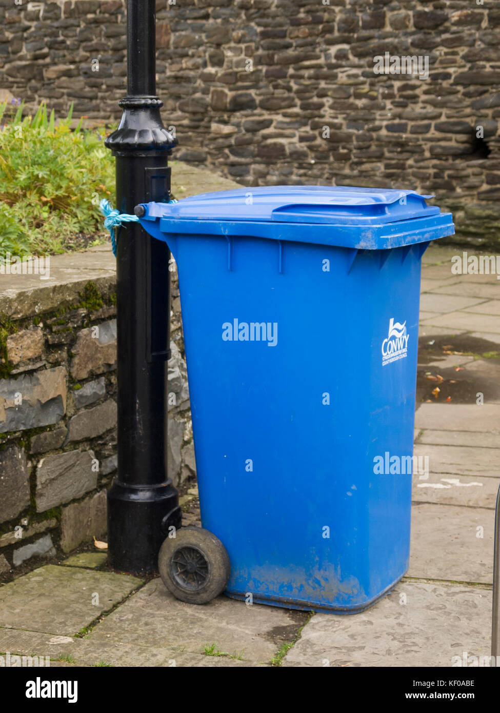 blue wheelie bin tied to lamp post Stock Photo - Alamy