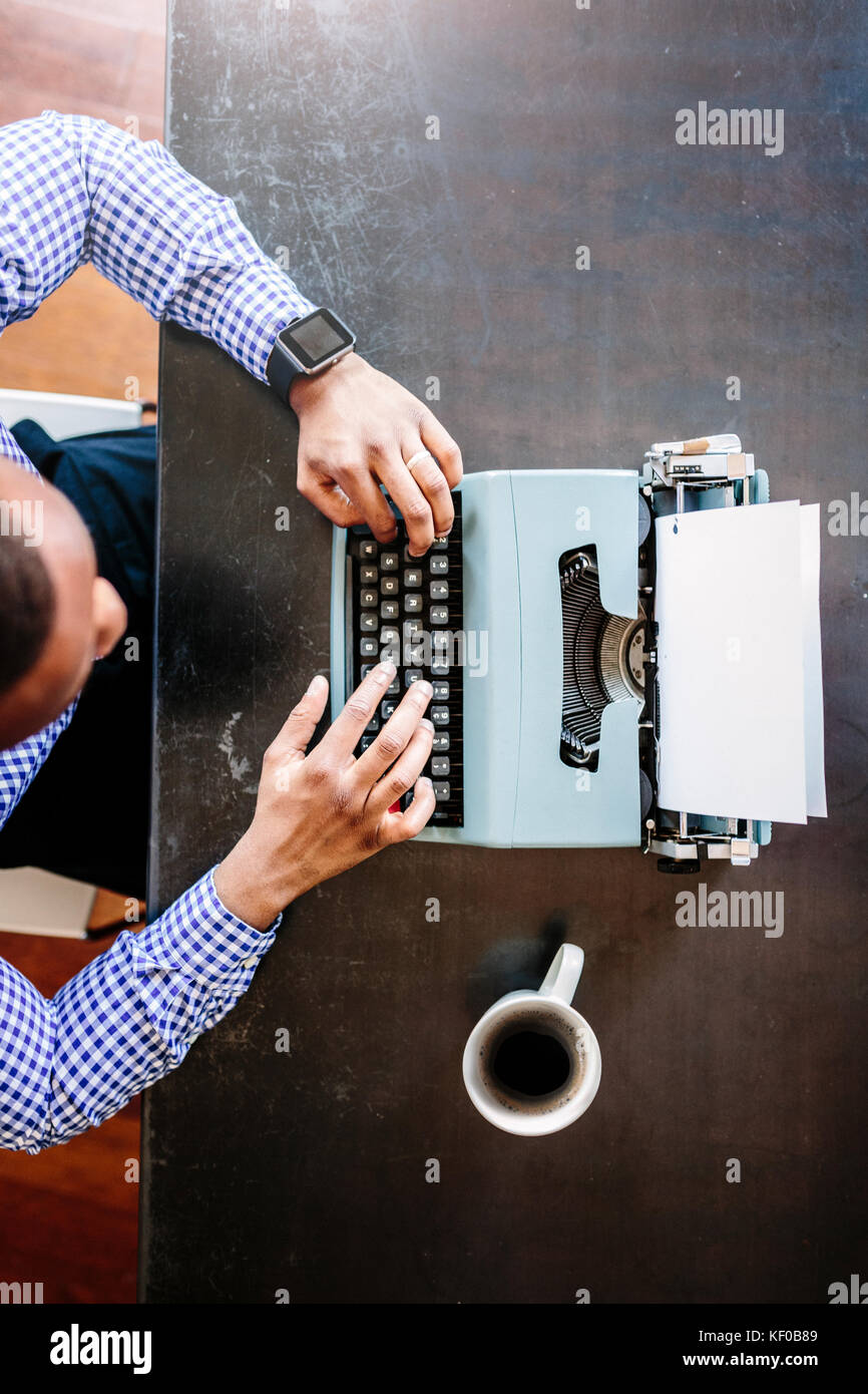 Young man at desk using typewriter Stock Photo - Alamy