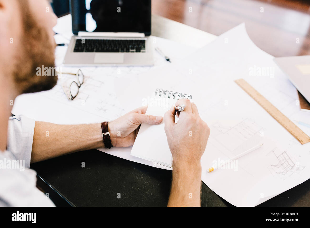 Architect taking notes at desk Stock Photo - Alamy