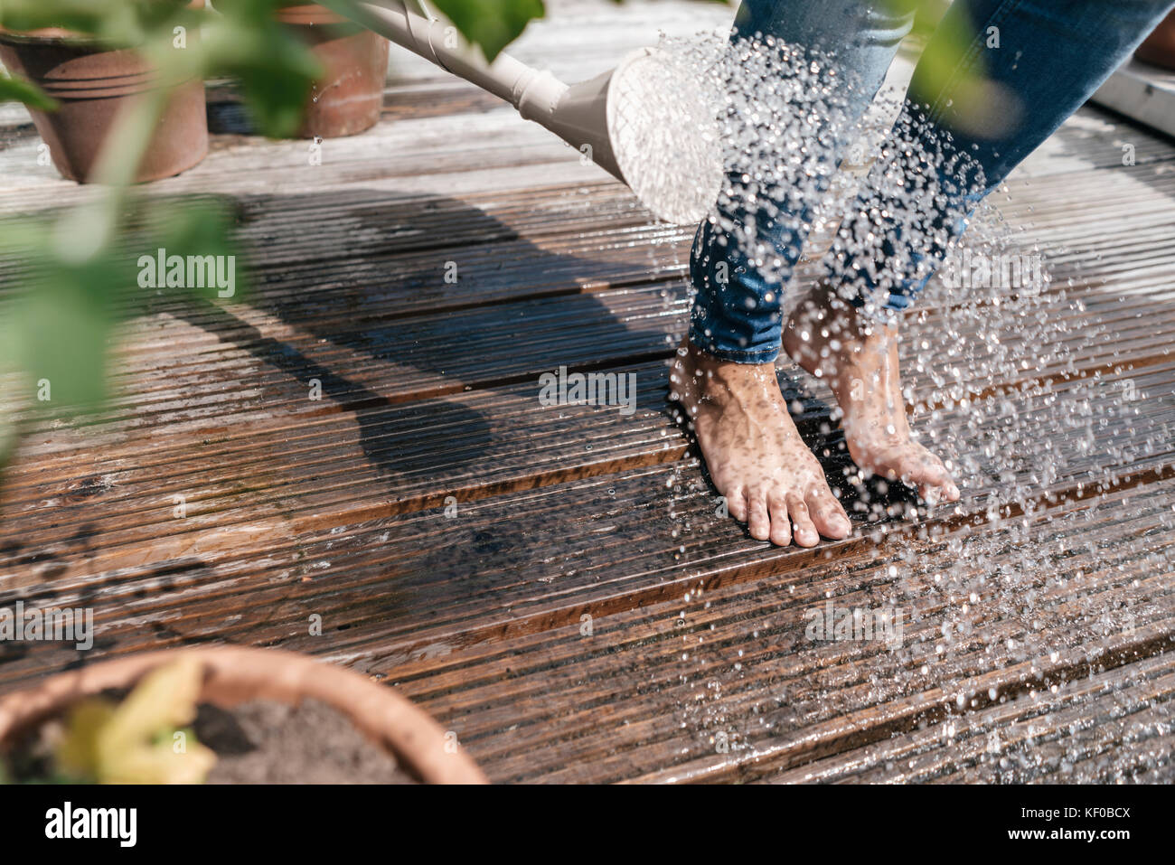 Woman with watering can pouring water over her feet Stock Photo - Alamy