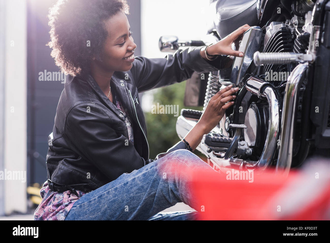Young woman maintaining her motorcycle Stock Photo - Alamy