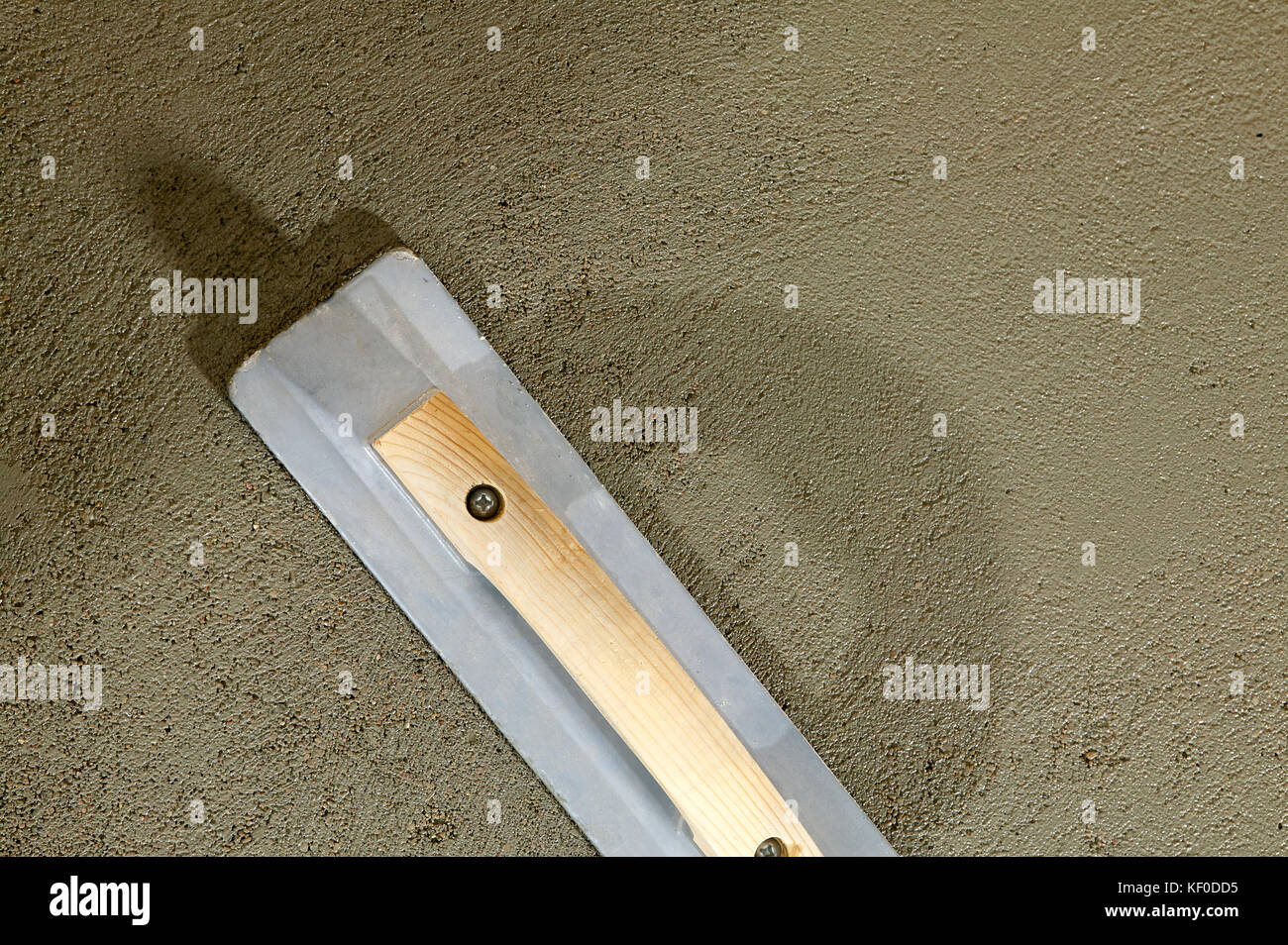 A close up crop of a concrete finishing screed on finished wet cement ...