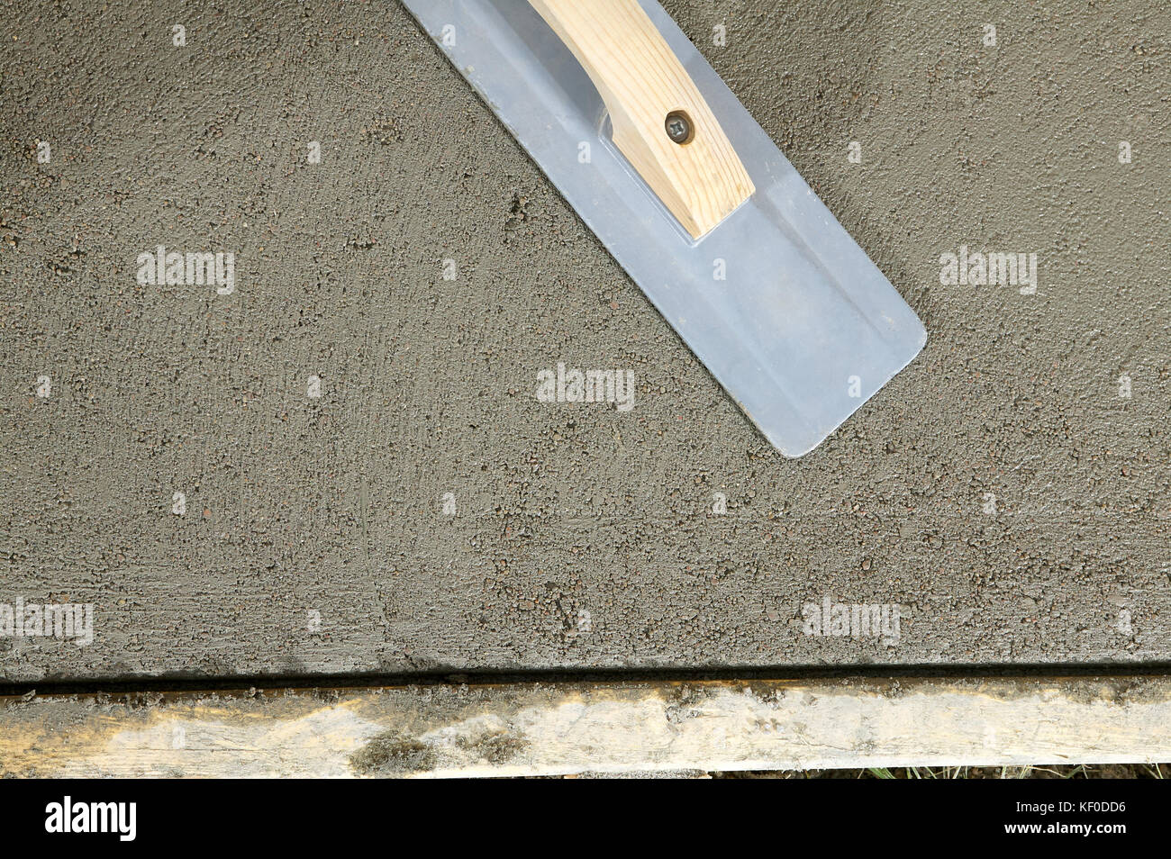 A close up crop of a concrete finishing screed on finished wet cement ...