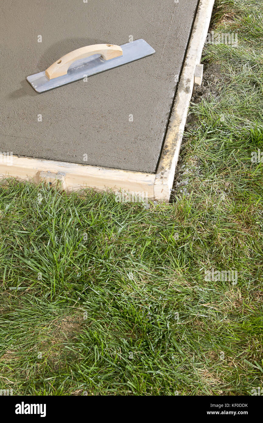 A close up crop of a finished wet cement foundation and concrete screed ...
