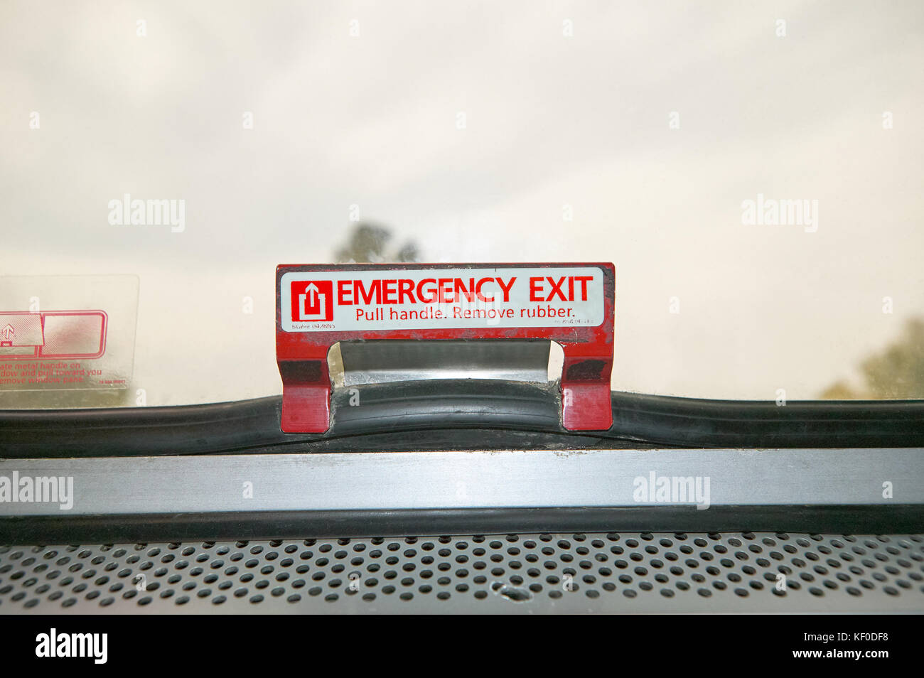 Close up front view of a red and white emergency exit sign and latch on ...