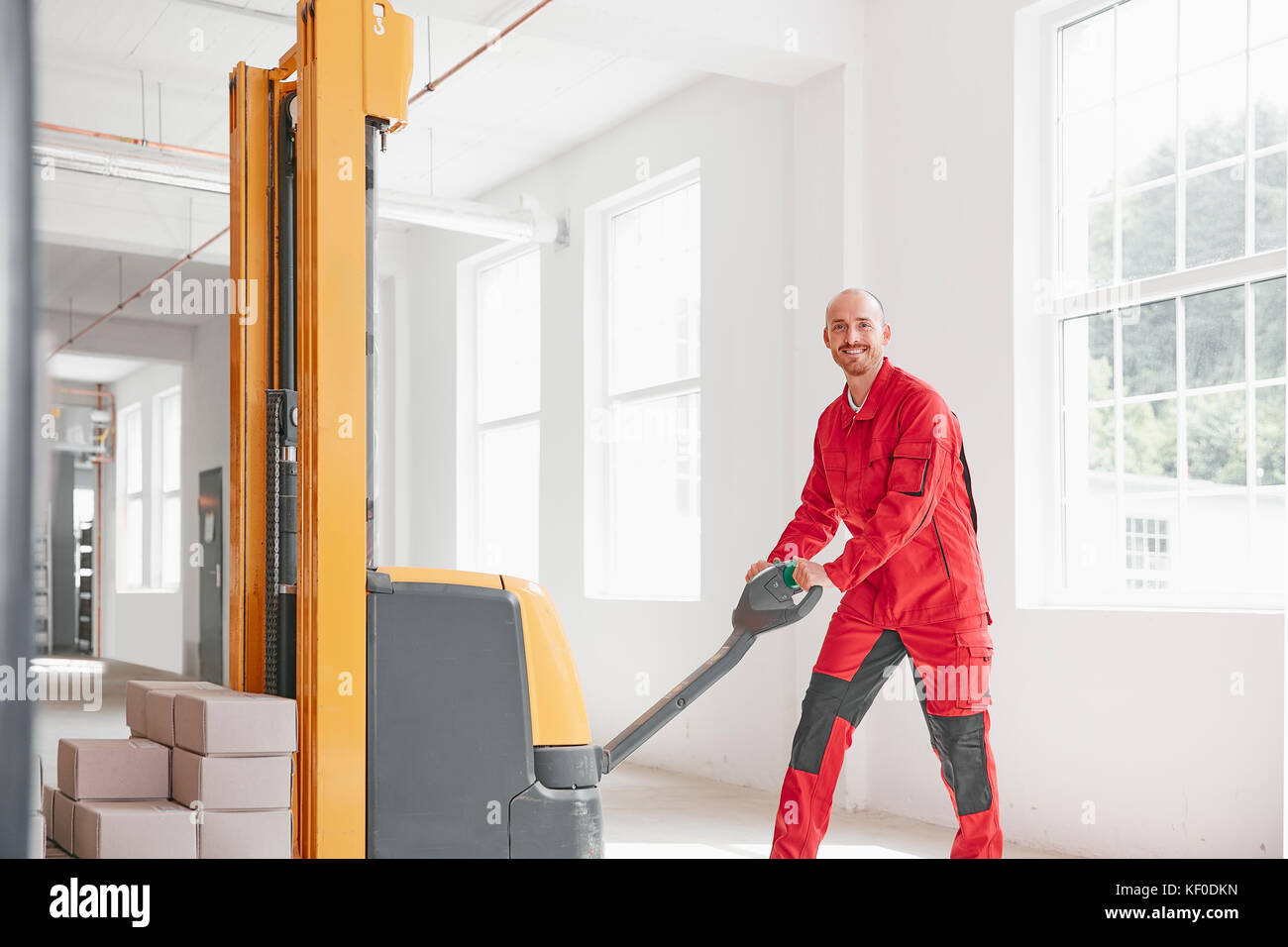 Portrait of smiling man in factory using forklift Stock Photo - Alamy