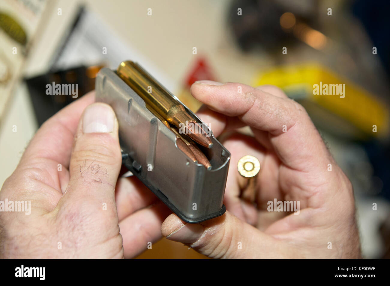 A close up of a person holding an ammunition cartridge full of rifle ...