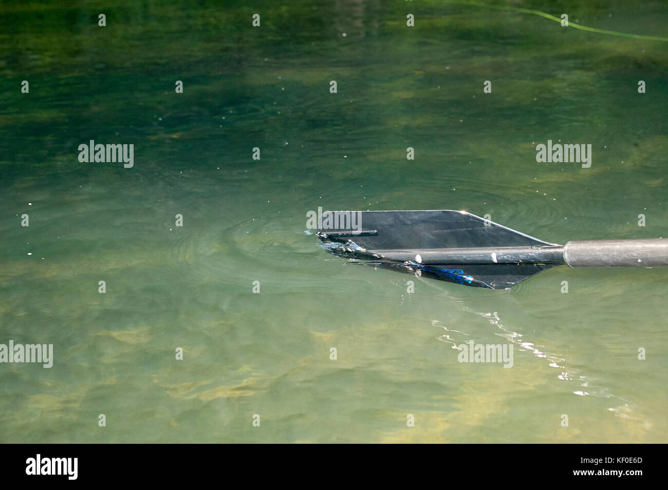Paddle from a kayak or canoe passing through freshwater in a close up ...