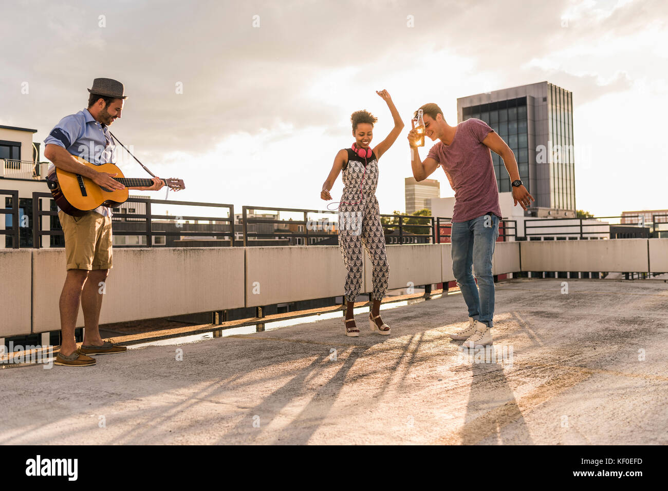 Three friends having a rooftop party Stock Photo - Alamy