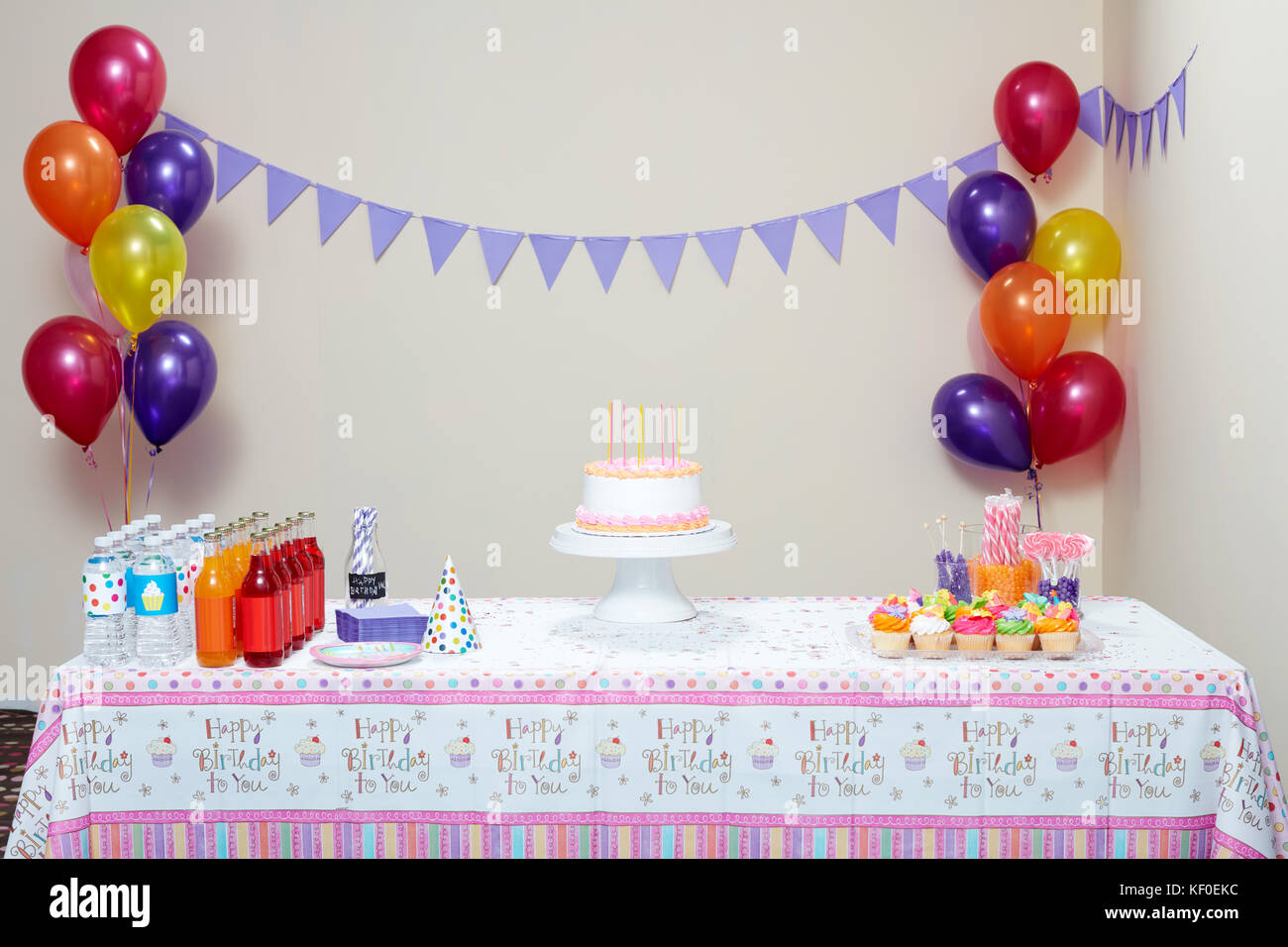Table with cake, beverages set for birthday party with balloons in ...