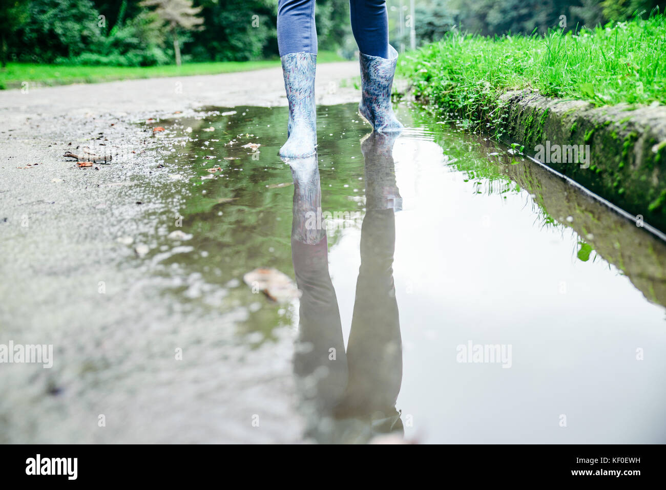 woman legs walking by puddle in rubber boots Stock Photo - Alamy