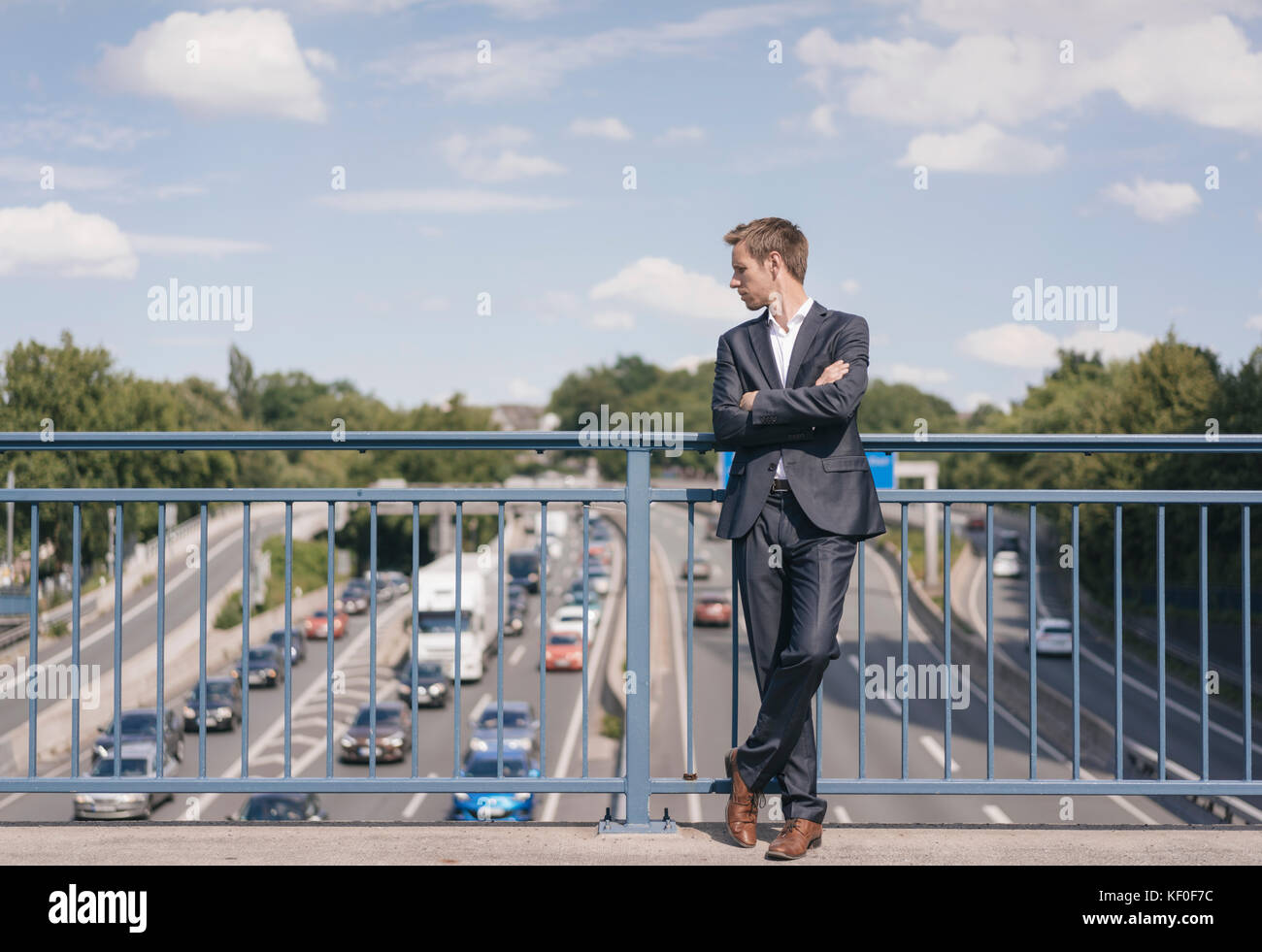 Businessman standing on a bridge over a motorway Stock Photo - Alamy