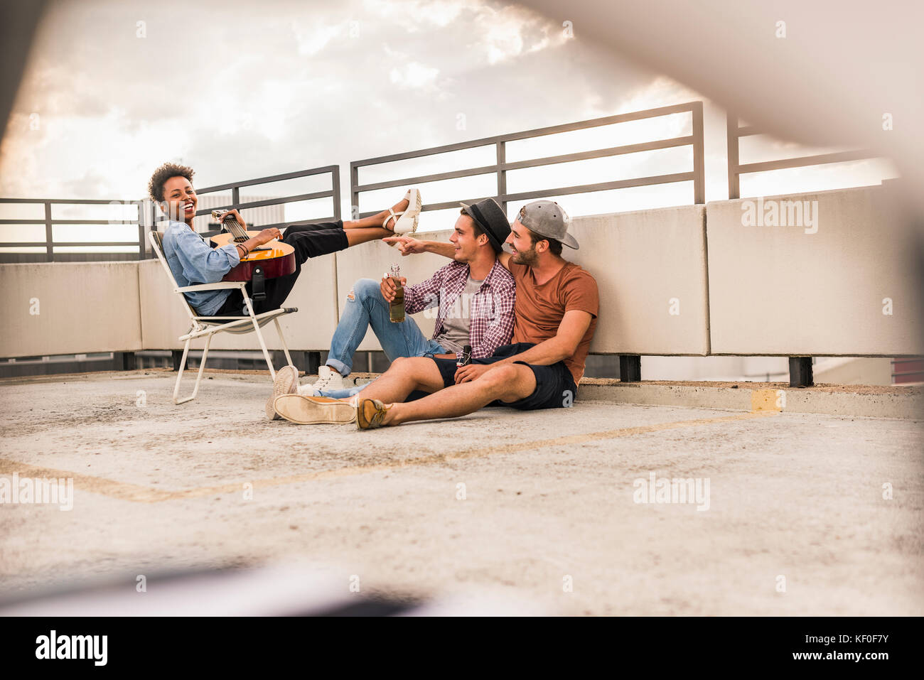 Three friends having a rooftop party Stock Photo - Alamy