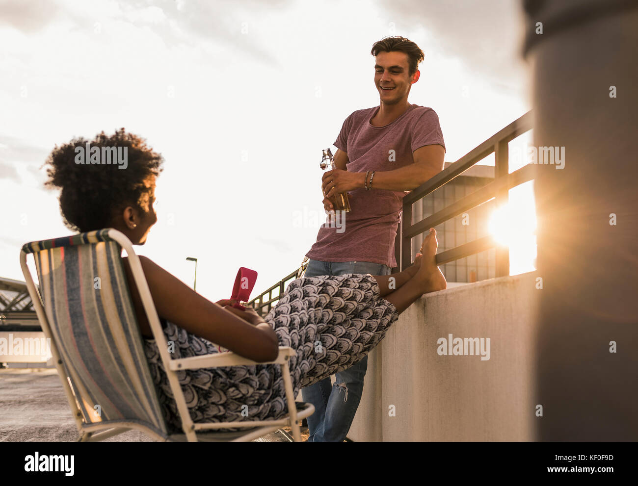 Young couple socializing on rooftop Stock Photo - Alamy
