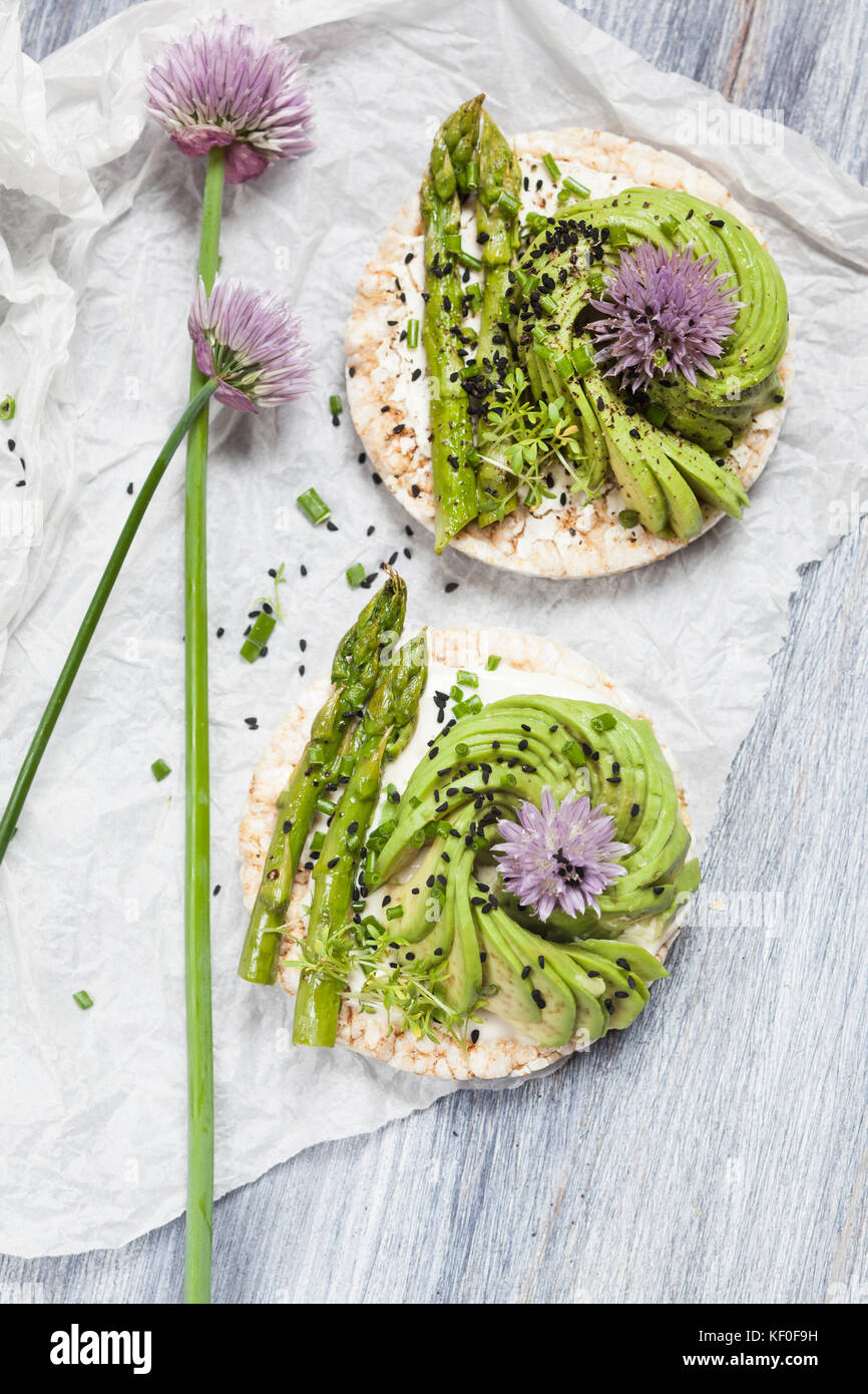 Rice cakes with cream cheese, avocado and asparagus garnished with ...