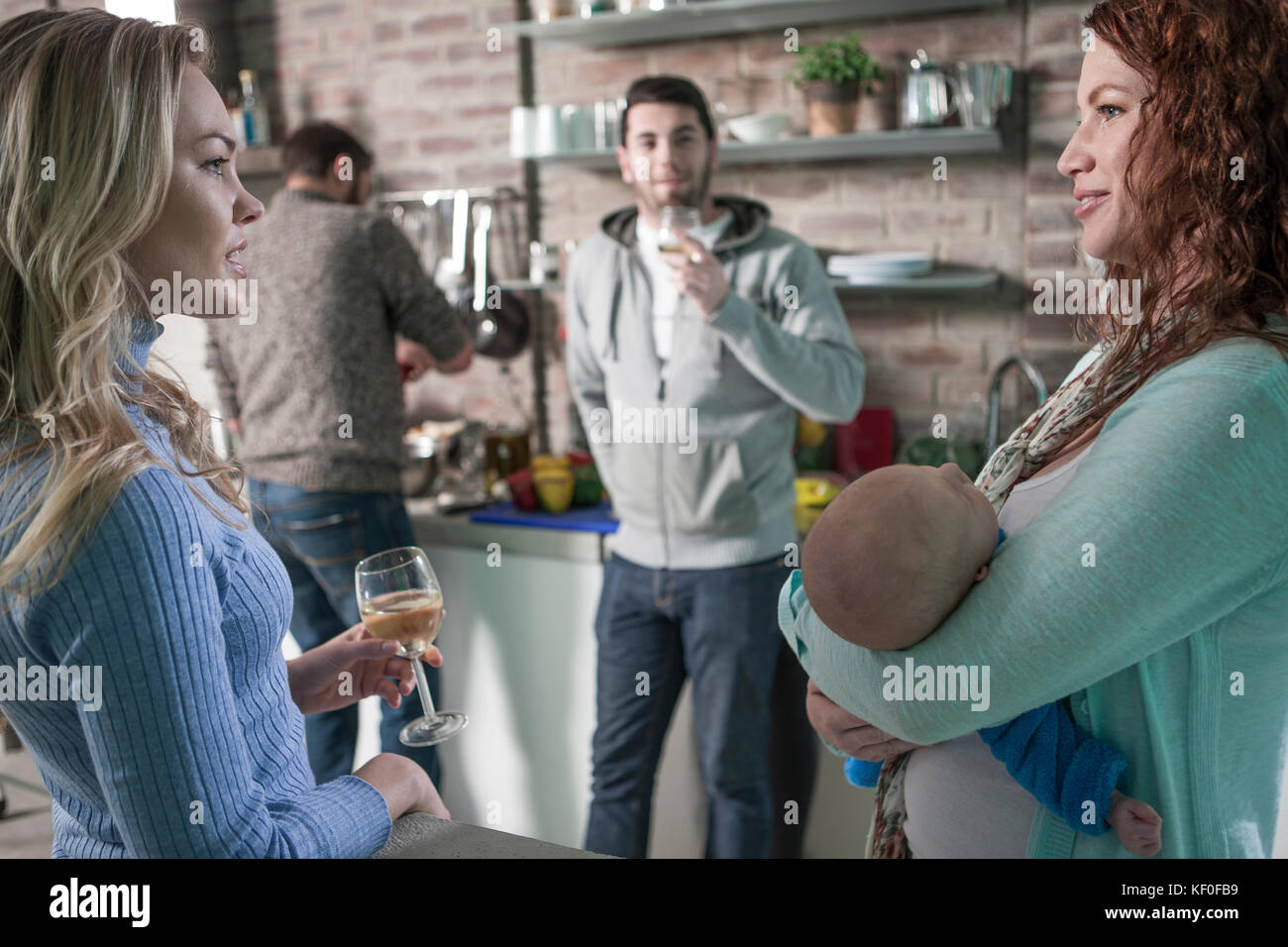 Family and friends with baby in kitchen Stock Photo - Alamy