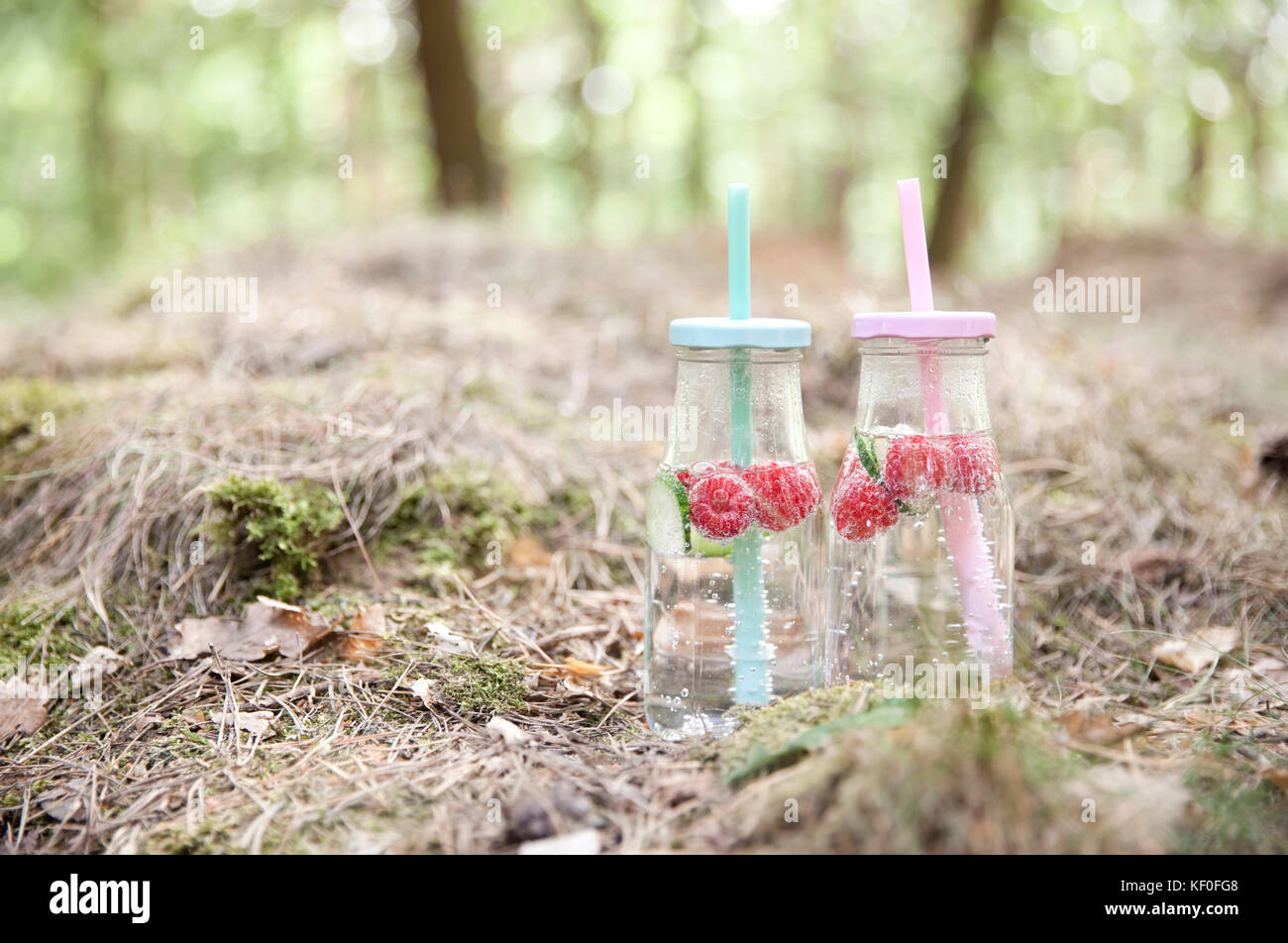 Two glasses of infused water with cucumber slices and raspberries in ...