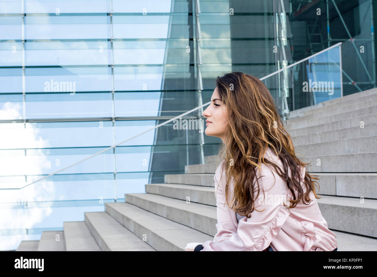 Young woman sitting on stairs Stock Photo - Alamy