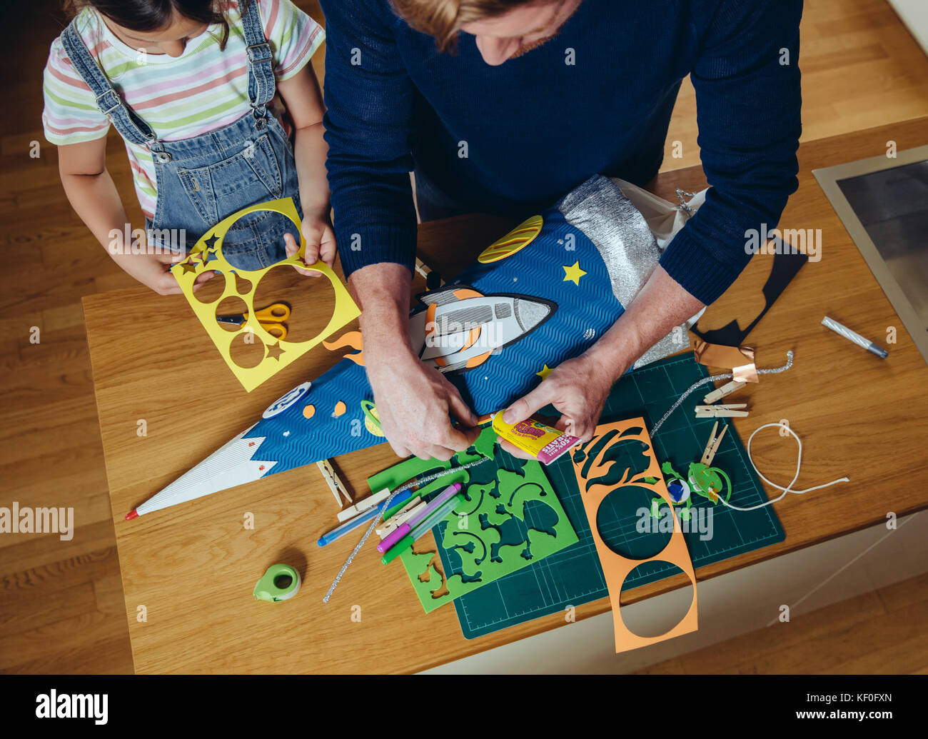 Father and daughter creating her space themed school cone at home Stock ...
