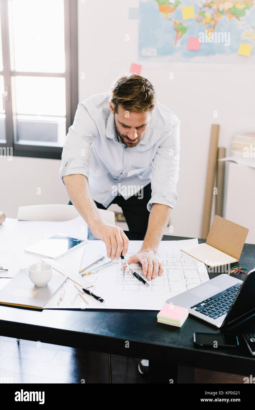 Architect working on construction plan Stock Photo - Alamy