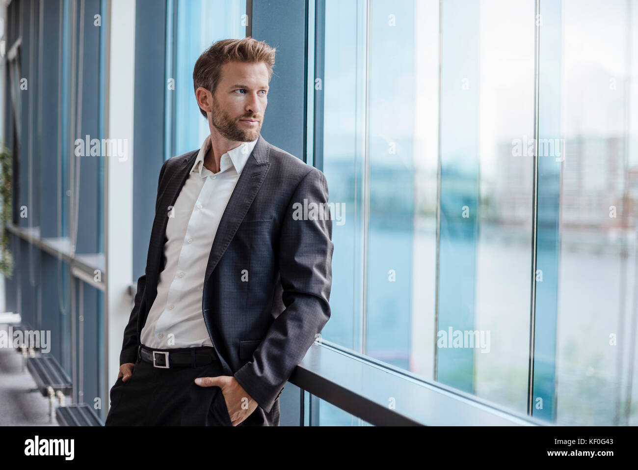 Businessman standing window looking distance hi-res stock photography ...