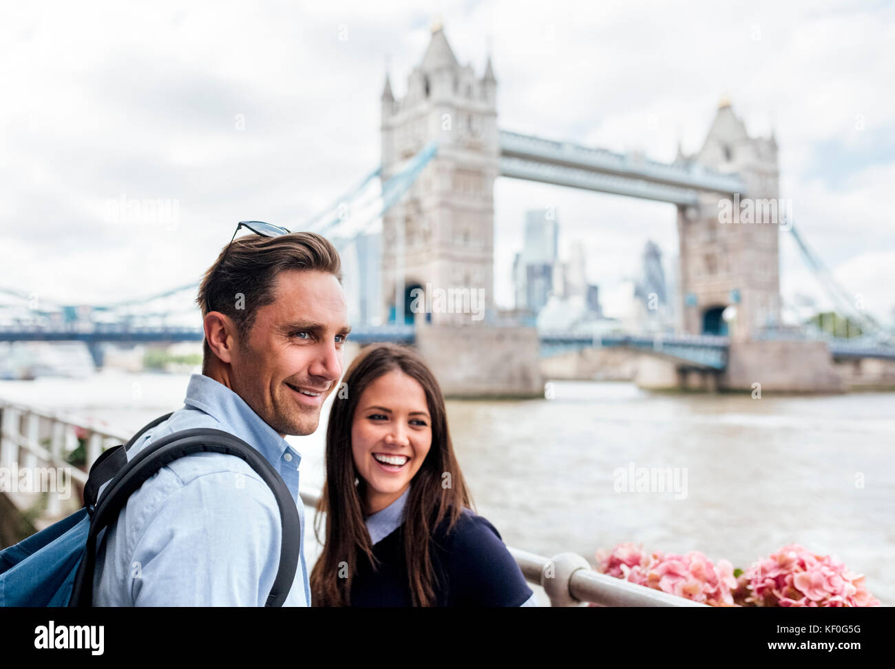 UK, London, smiling couple with the Tower Bridge in the background ...