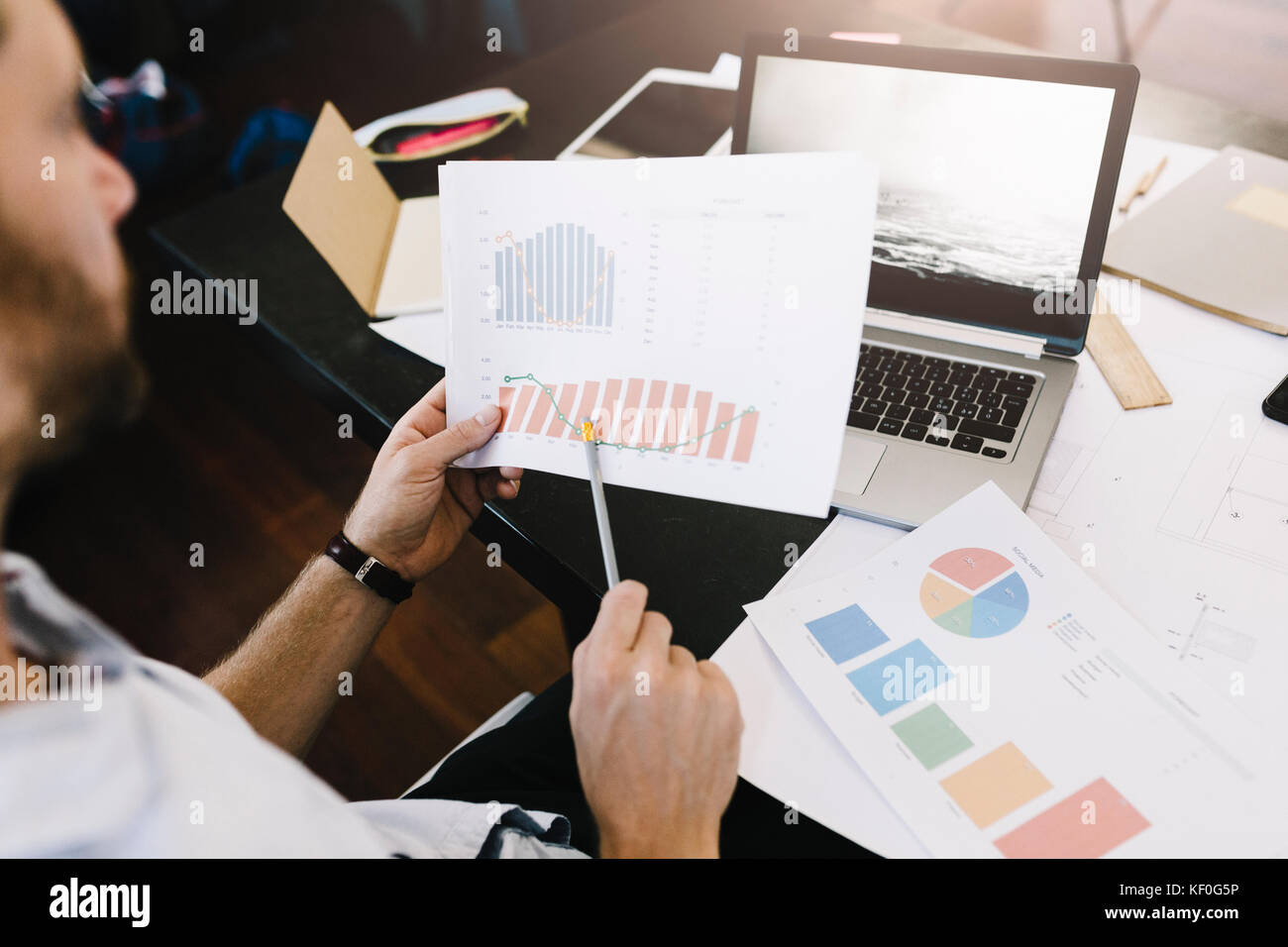 Man with graph at desk Stock Photo - Alamy