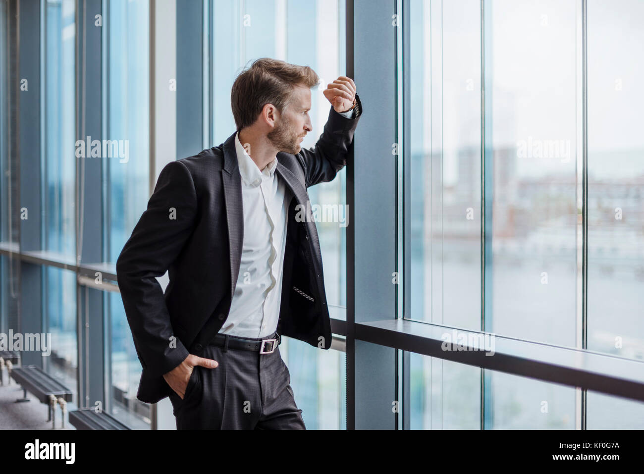 Businessman standing window looking distance hi-res stock photography ...