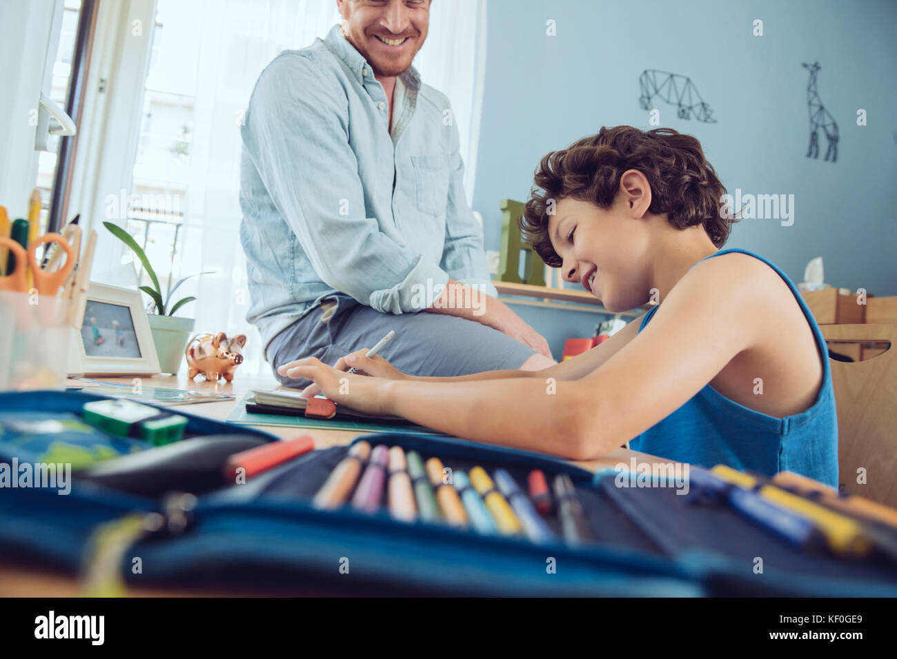 Father helping boy doing his schoolwork at home Stock Photo - Alamy