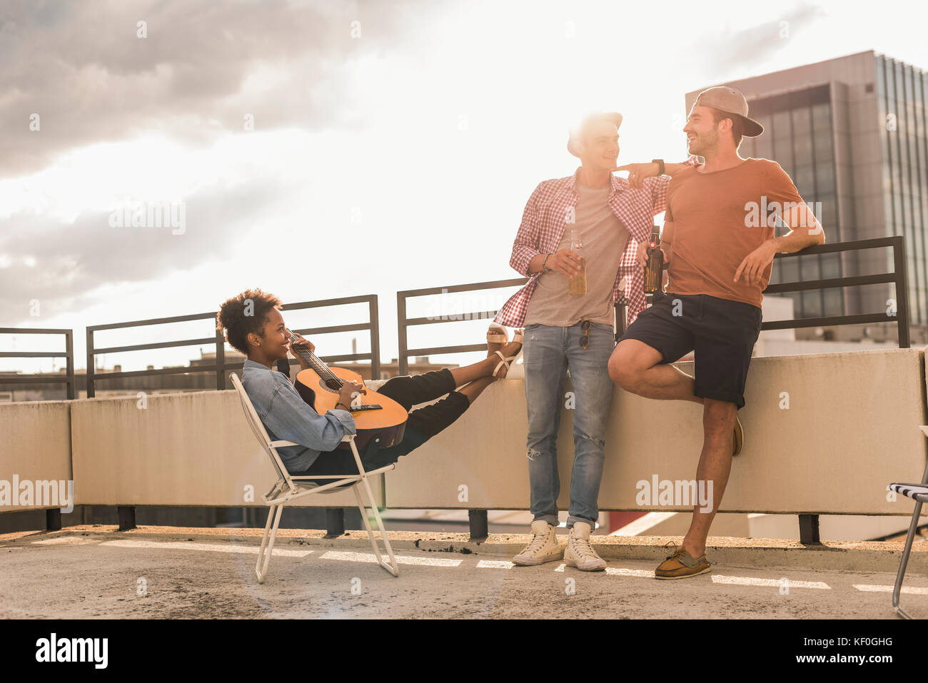 Three friends having a rooftop party Stock Photo - Alamy