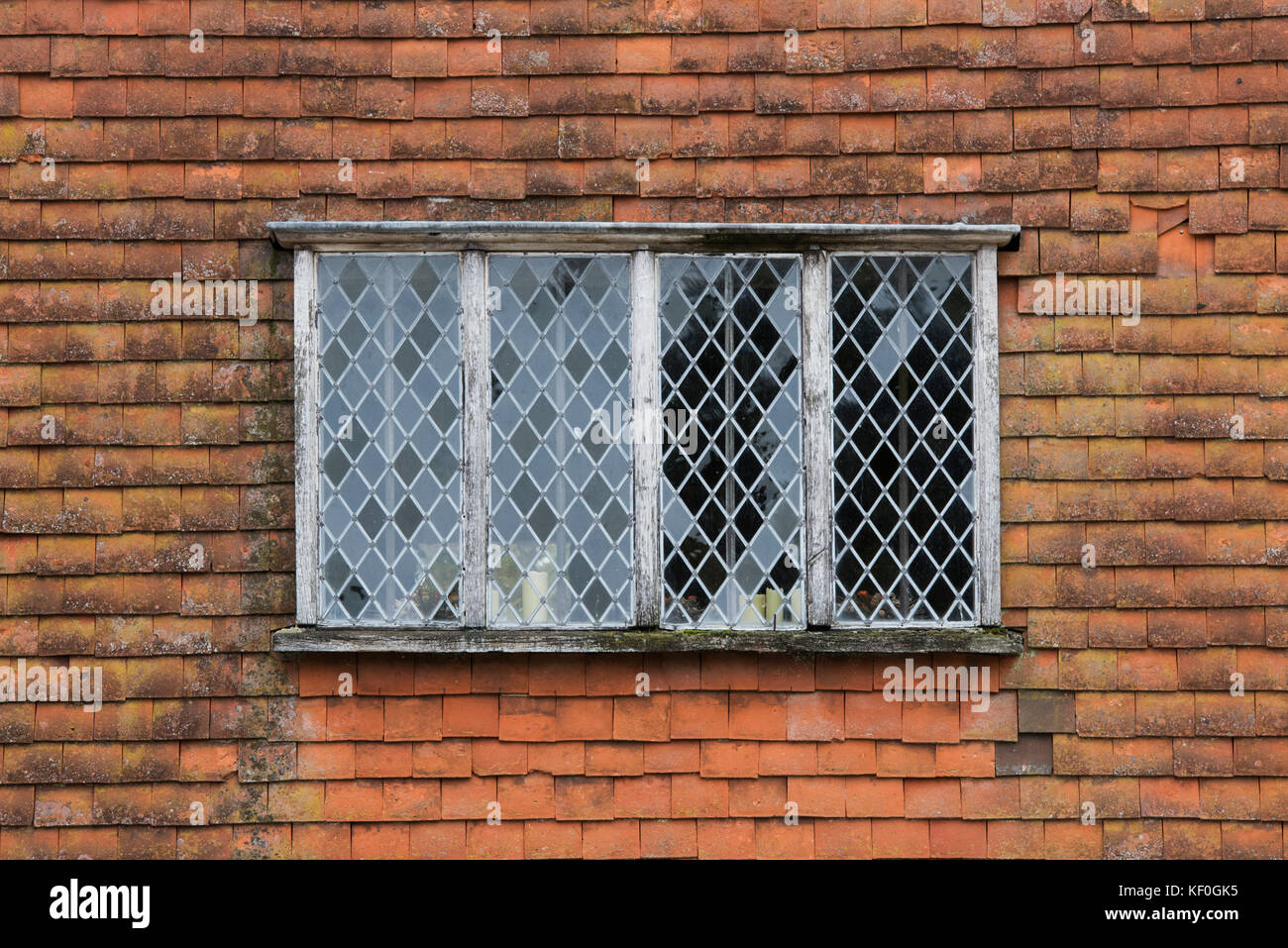 Red terracotta wall tiles with leaded diamond windows detail at Weald ...