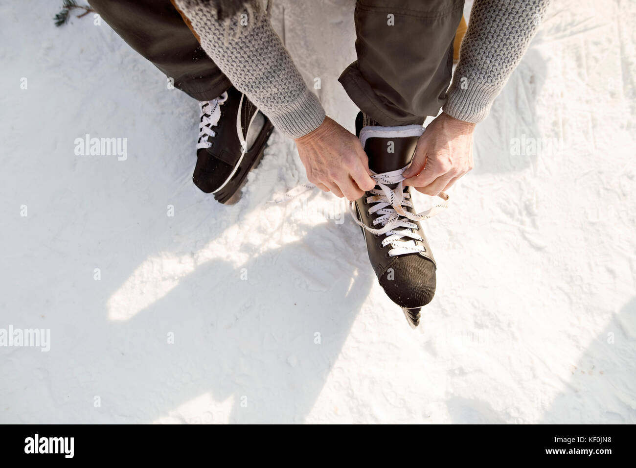 Man putting on ice skates Stock Photo - Alamy