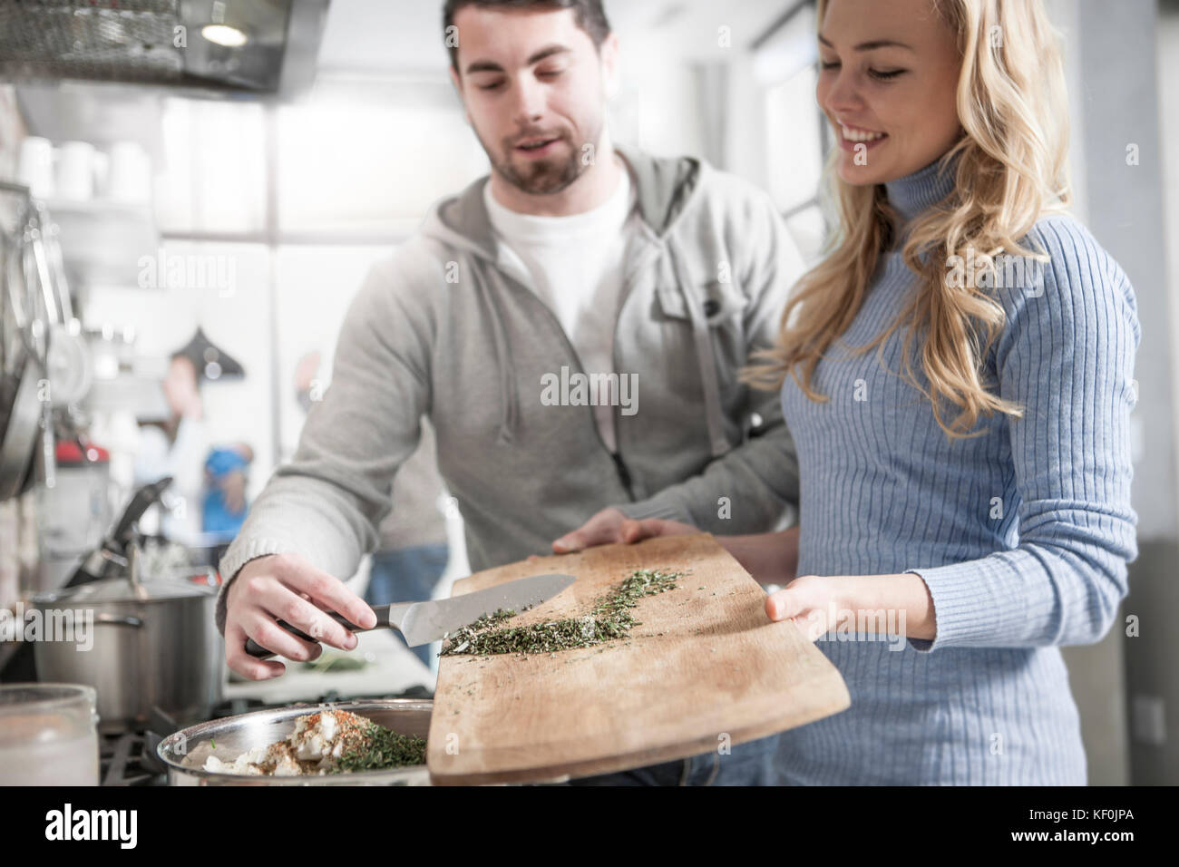 Couple helping one another moving spices in pot Stock Photo - Alamy