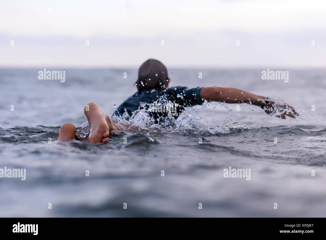 Back view of man on surfboard Stock Photo - Alamy