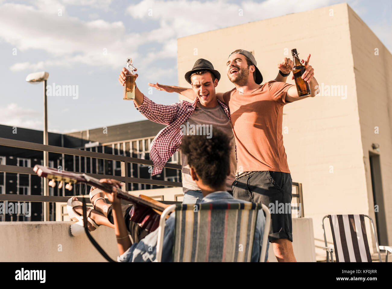 Three friends having a rooftop party Stock Photo - Alamy