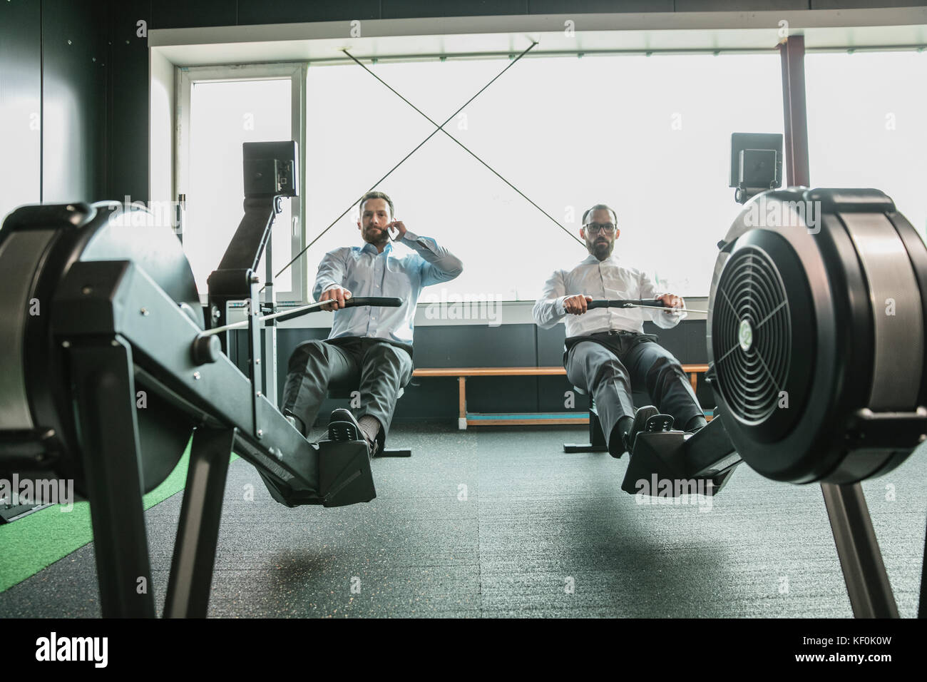 Businessmen training in gym, while making a phone call Stock Photo - Alamy
