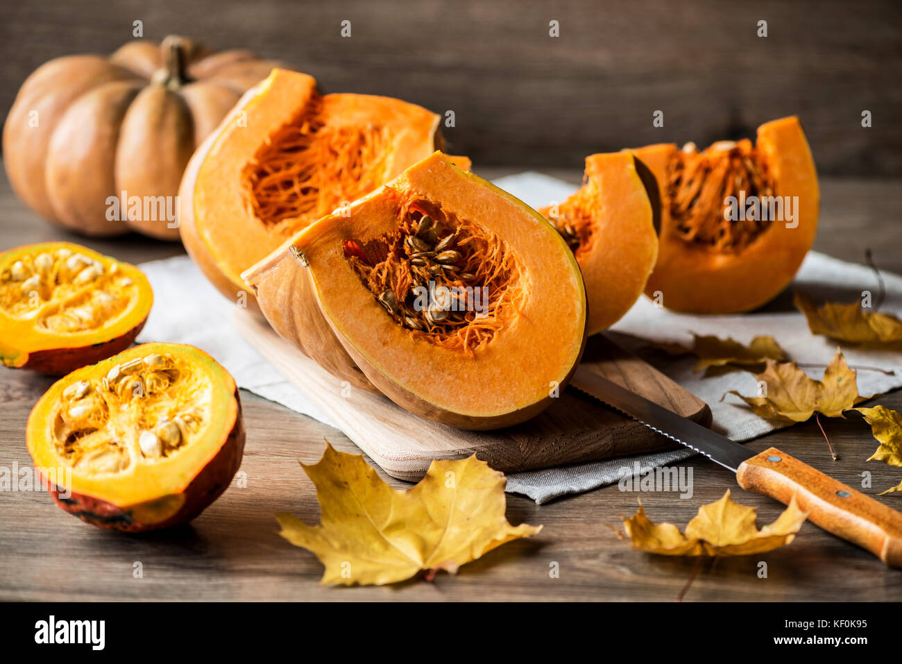 Sliced pumpkin with seeds on a wooden background. Close-up Stock Photo ...