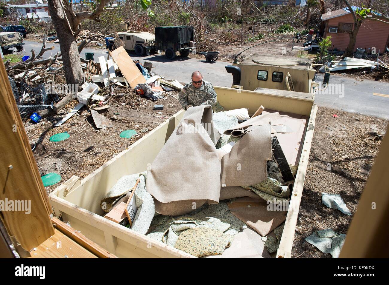 A U.S. National Guard soldier clears debris from a damaged home in the ... A U.S. National Guard soldier clears debris from a damaged home in the ...