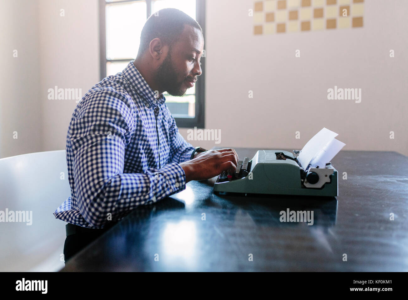 Young man at desk using typewriter Stock Photo - Alamy