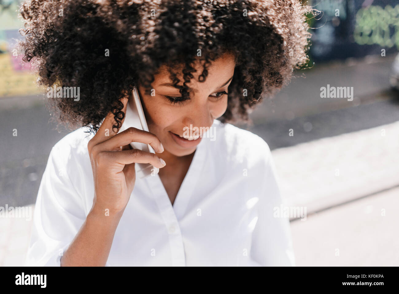 Smiling young woman on cell phone outdoors Stock Photo - Alamy