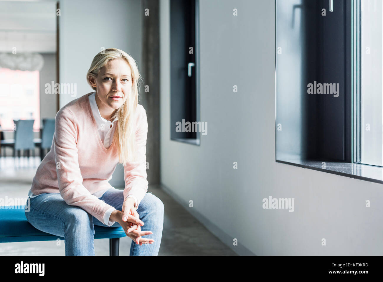 Portrait of woman sitting on bench Stock Photo - Alamy