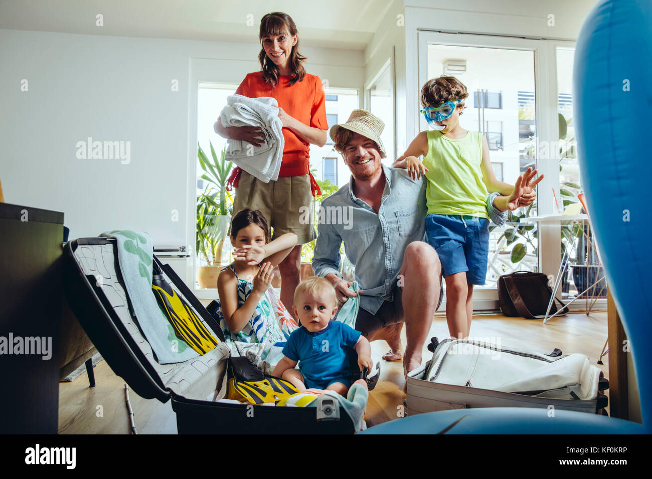 Happy family of five packing for holiday trip Stock Photo - Alamy