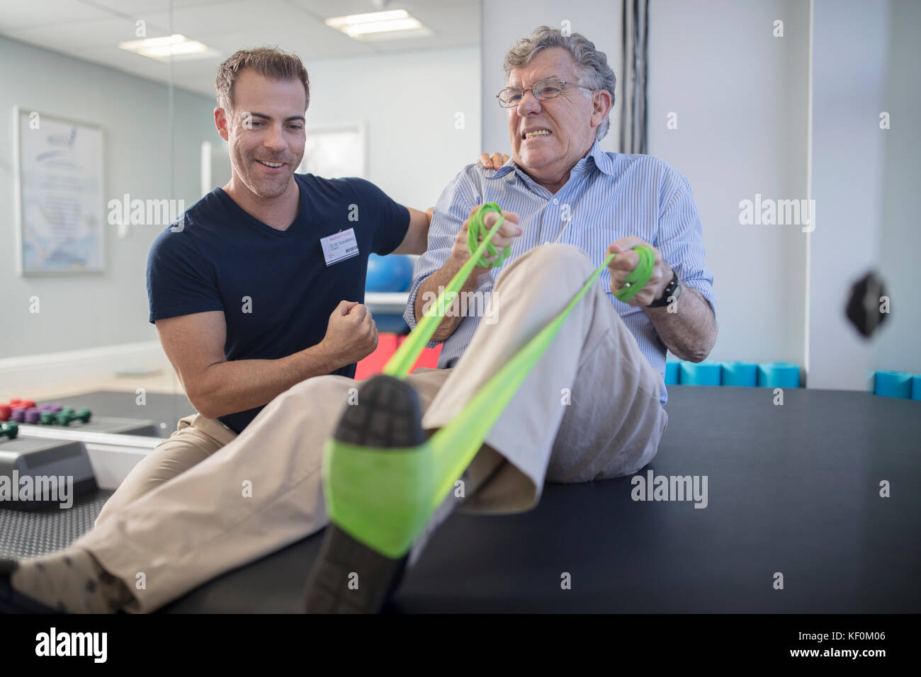 Senior man exercising with resistance band at physio's practice Stock ...