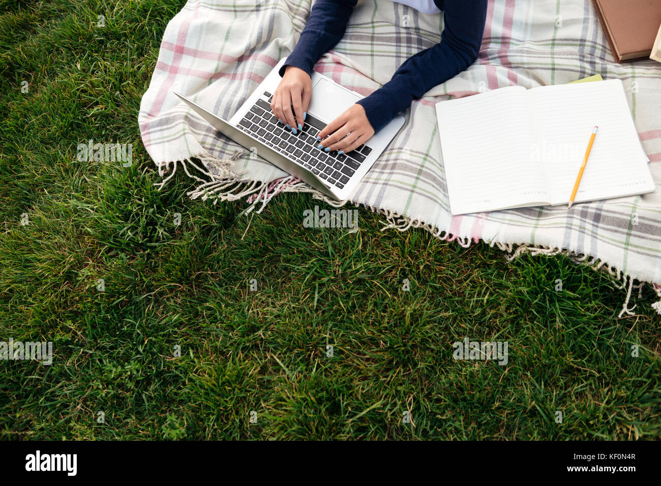 Top view of a female student studying on laptop computer while lying on ...
