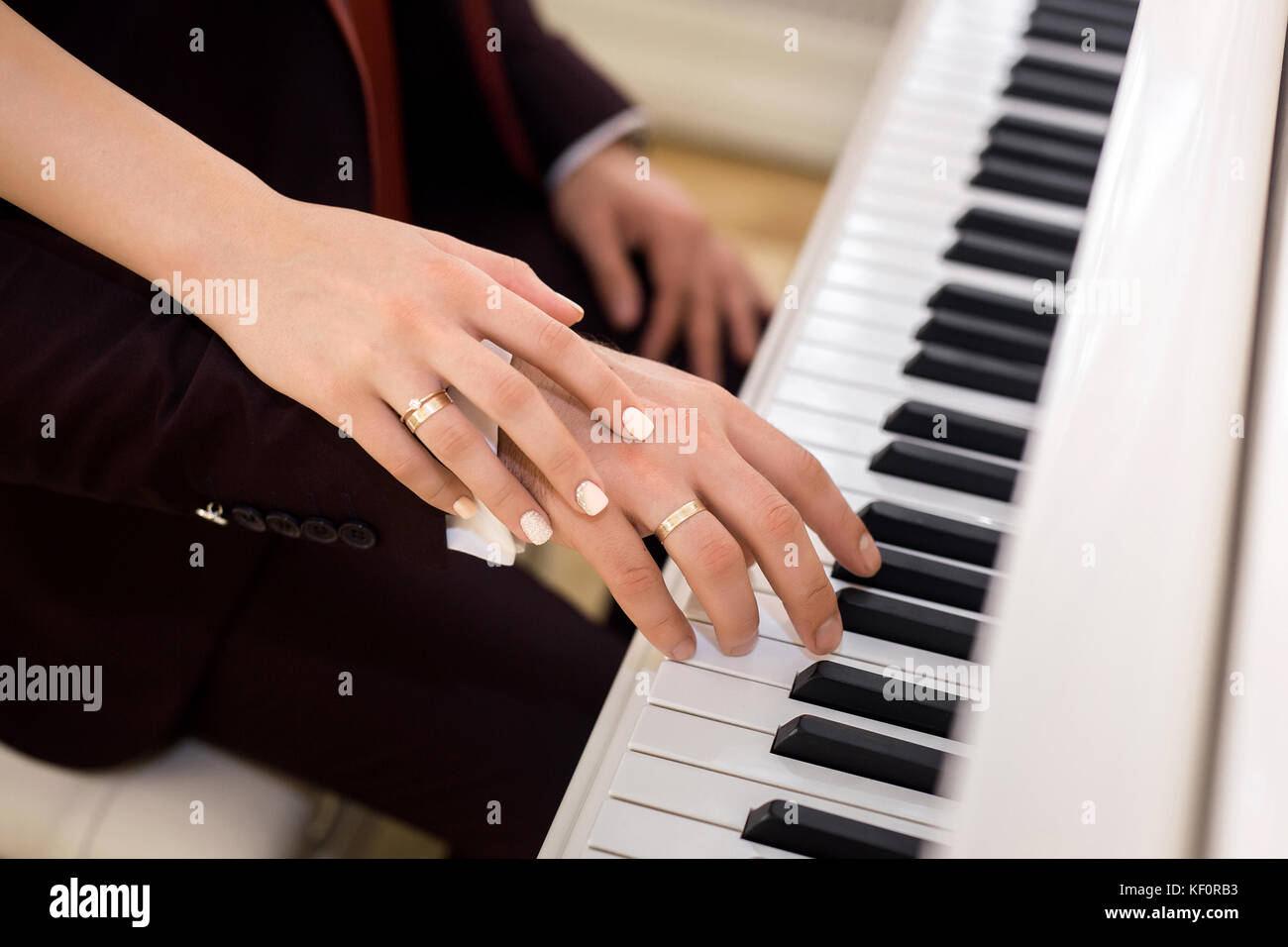 The groom and bride in playing the piano Stock Photo - Alamy