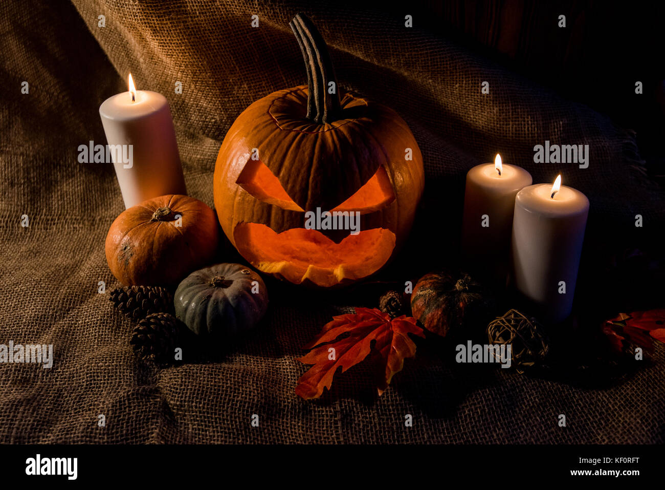 Scary jack-o-lantern, red leaves and candles Stock Photo - Alamy